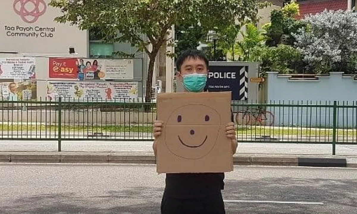 Singapore activist faces fine over one-man smiley face sign protest
